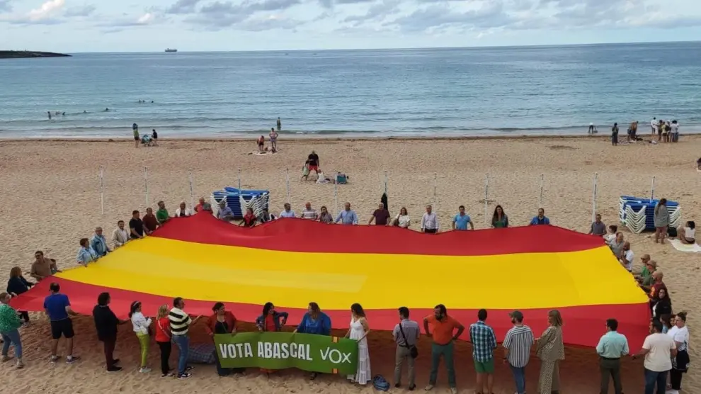 Vox despliega una enorme bandera de España en una playa de Santander